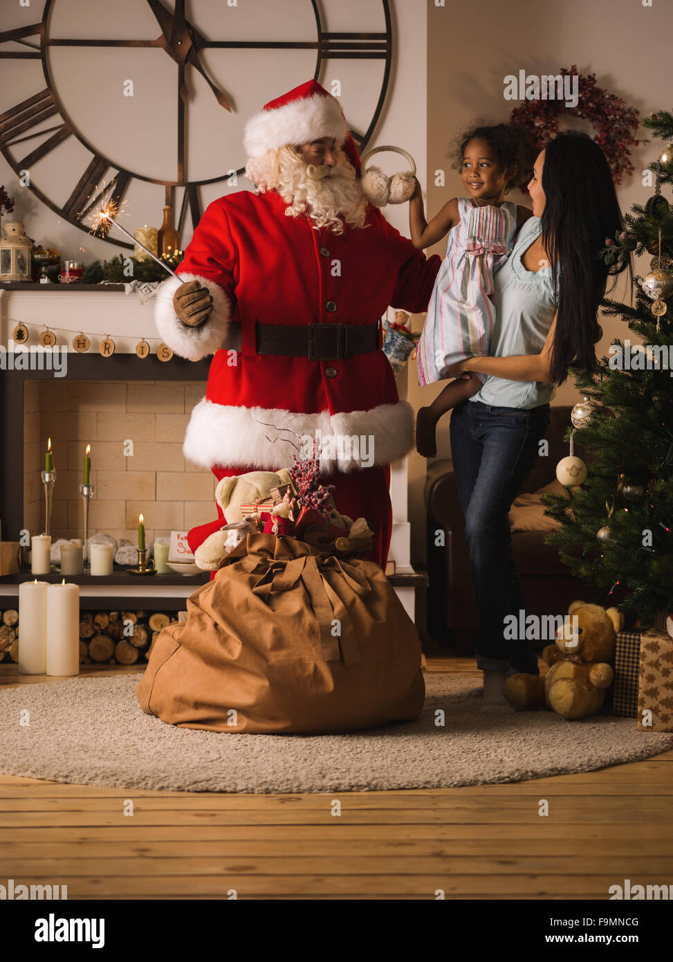 Santa Claus Surprising little Girl and her Mother at Home Stock Photo ...