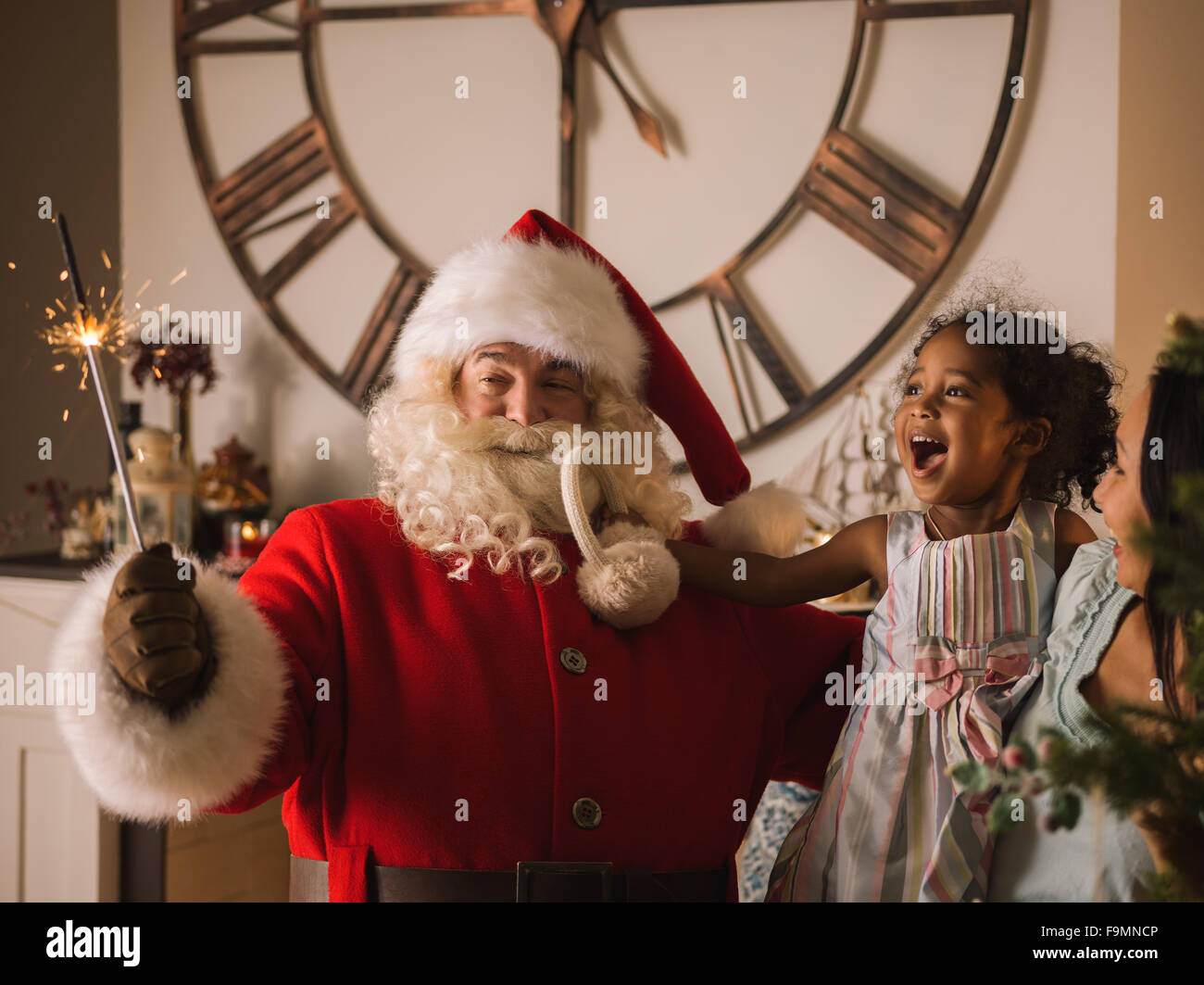 Santa Claus Surprising little Girl and her Mother at Home Stock Photo ...