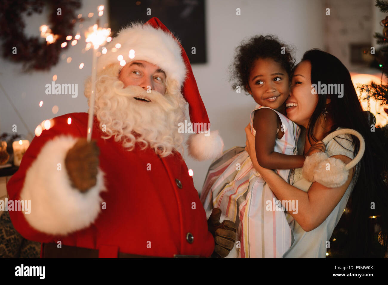 Santa Claus Surprising little Girl and her Mother at Home Stock Photo ...