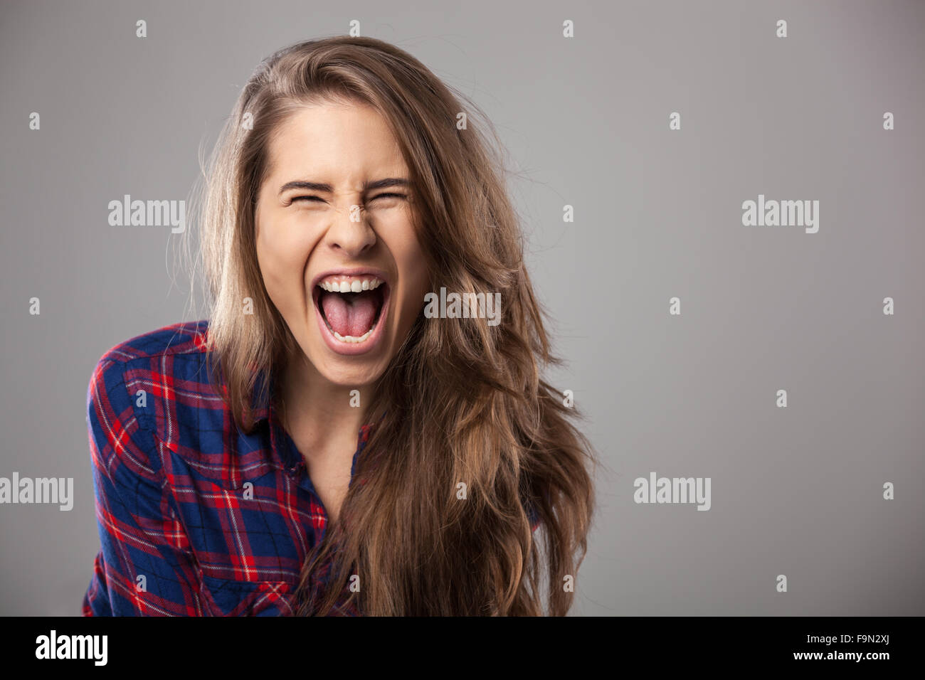 Young woman screaming loudly - studio portrait Stock Photo - Alamy