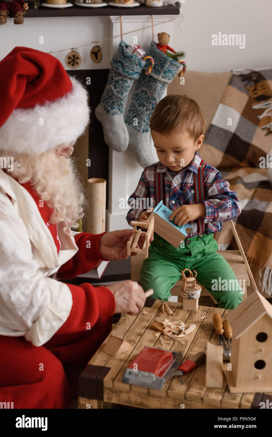 Santa Claus with Child making Christmas Gifts and Toys at Home Stock ...