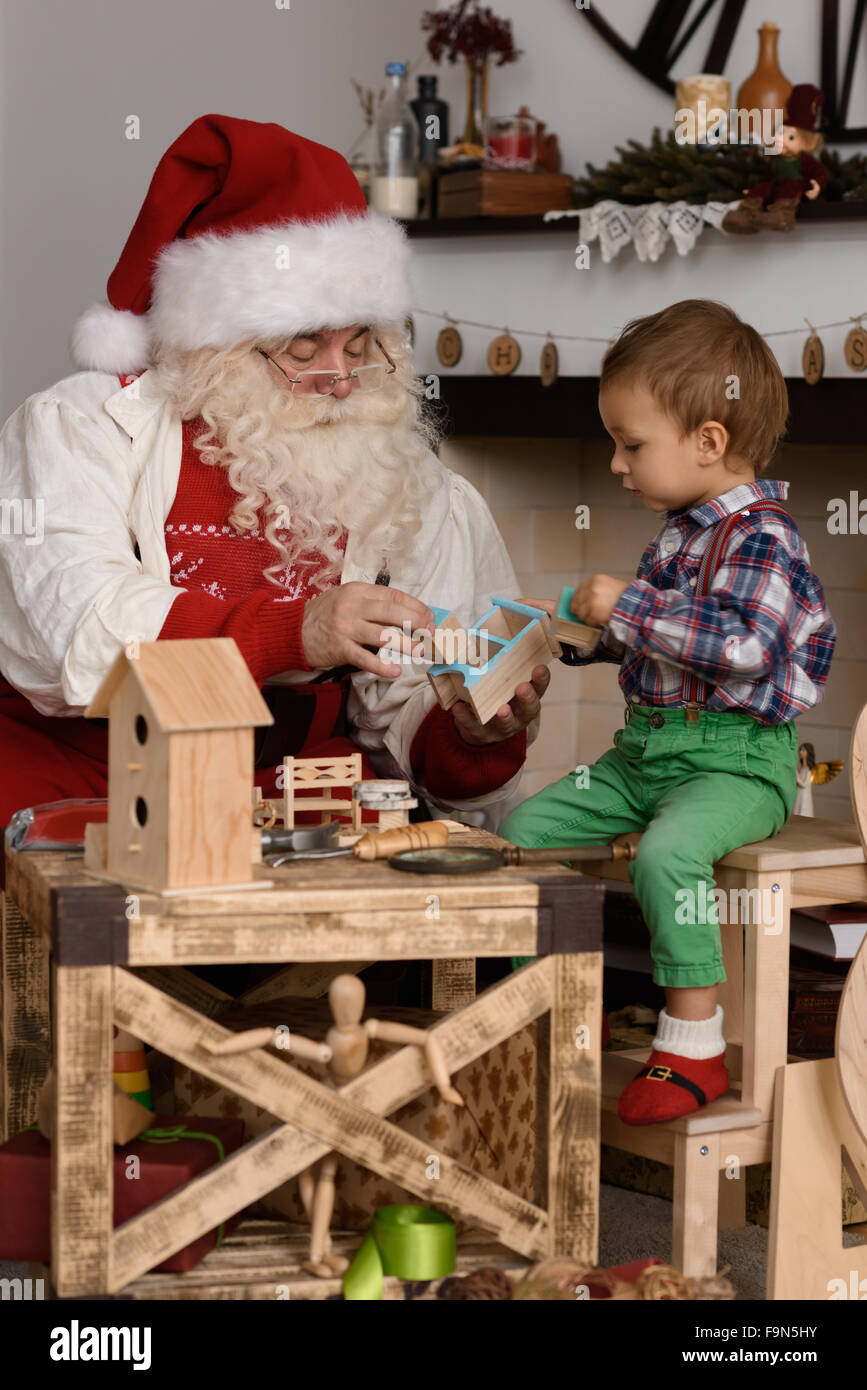 Santa Claus with Child making Christmas Gifts and Toys at Home Stock ...