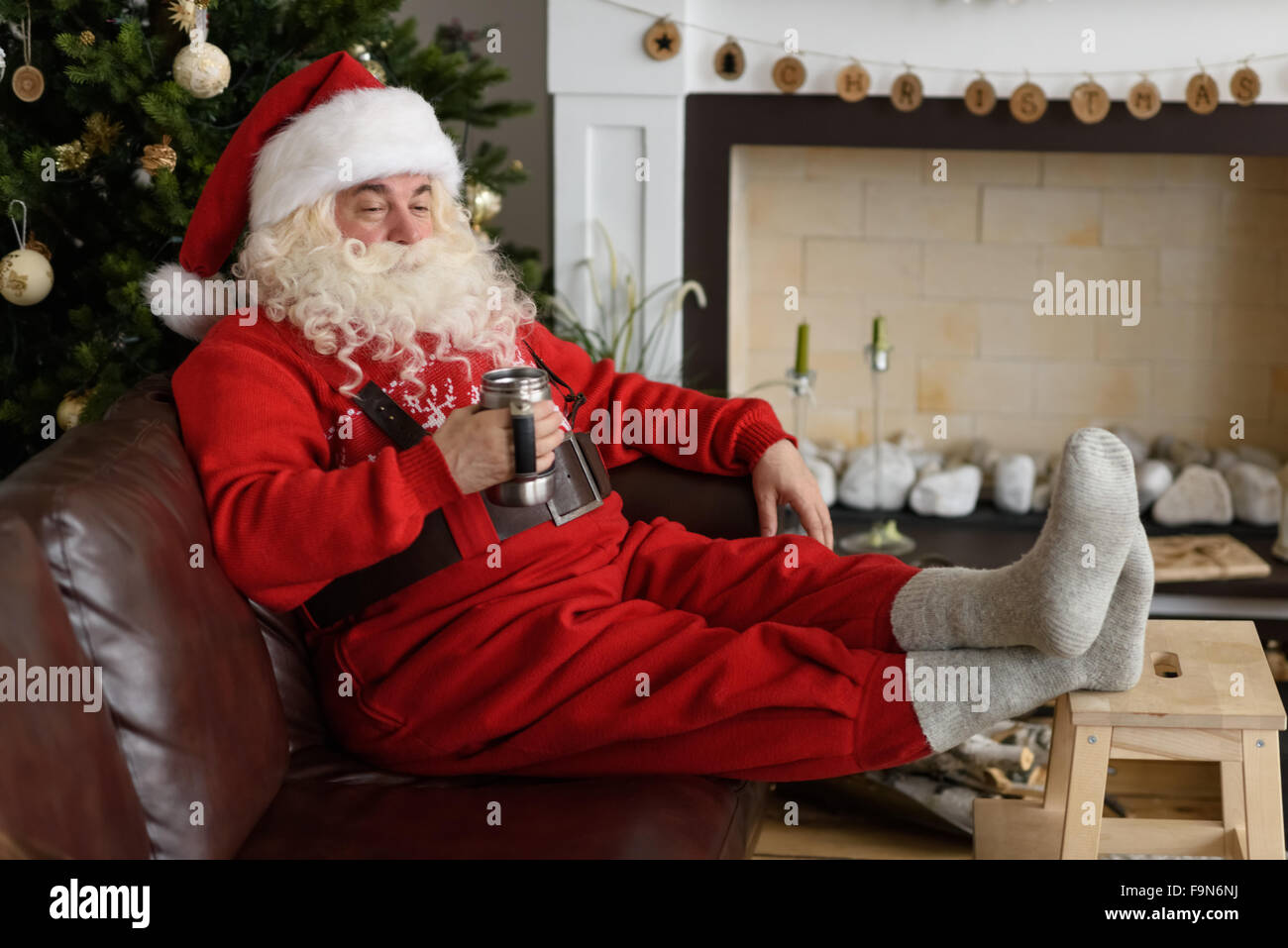 Santa Claus Drinking Tea near Christmas Tree at Home Stock Photo - Alamy