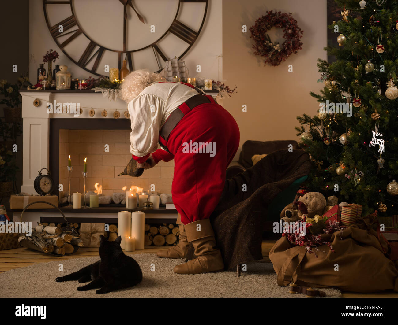 Santa Claus making Fire in Fireplace at Home Stock Photo - Alamy