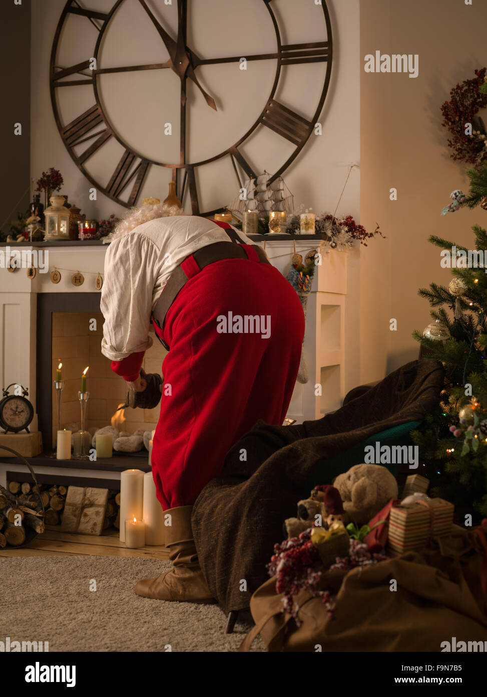 Santa Claus making Fire in Fireplace at Home Stock Photo - Alamy