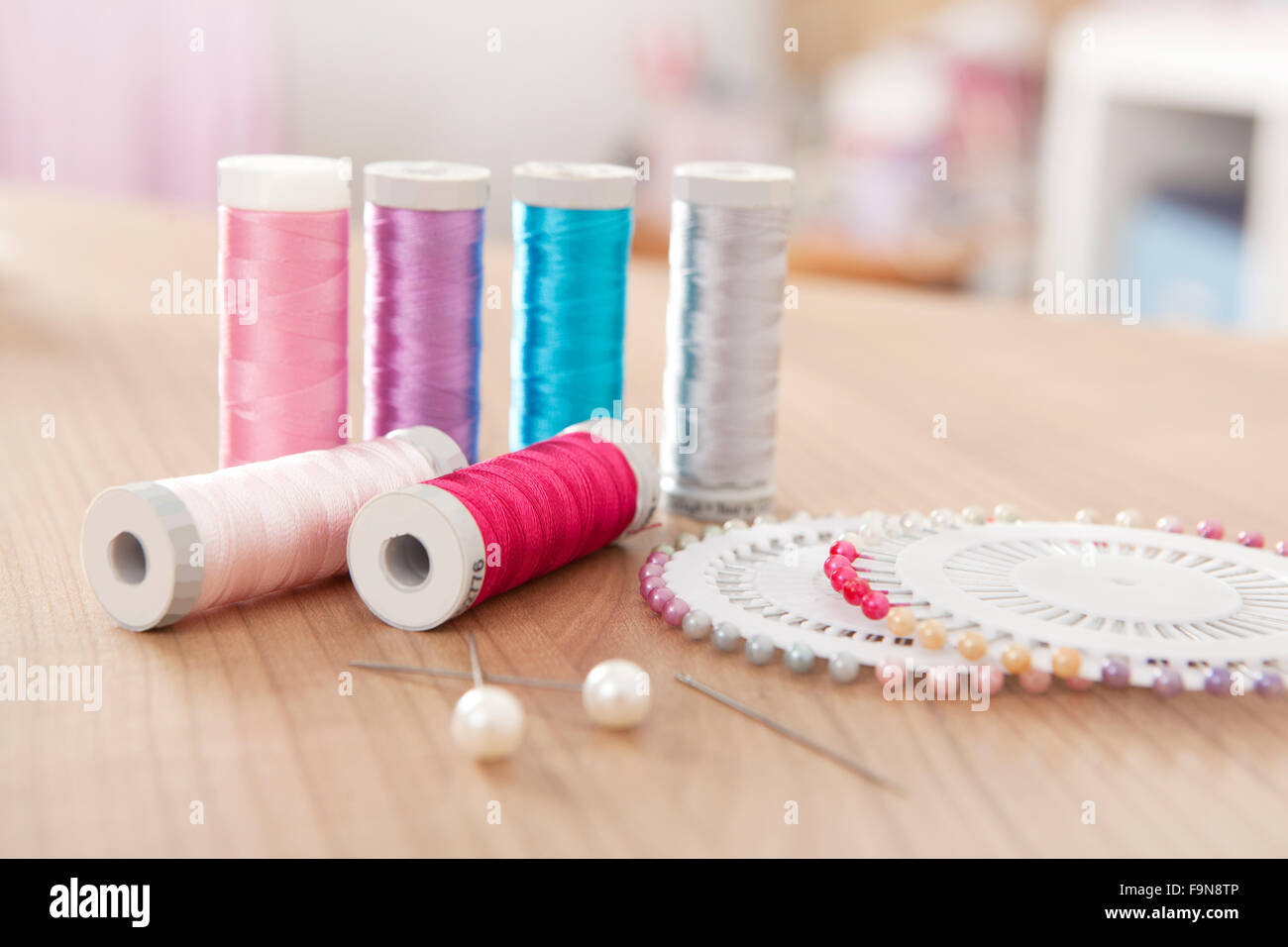 Sewing thread in different colors with pins on a table Stock Photo - Alamy