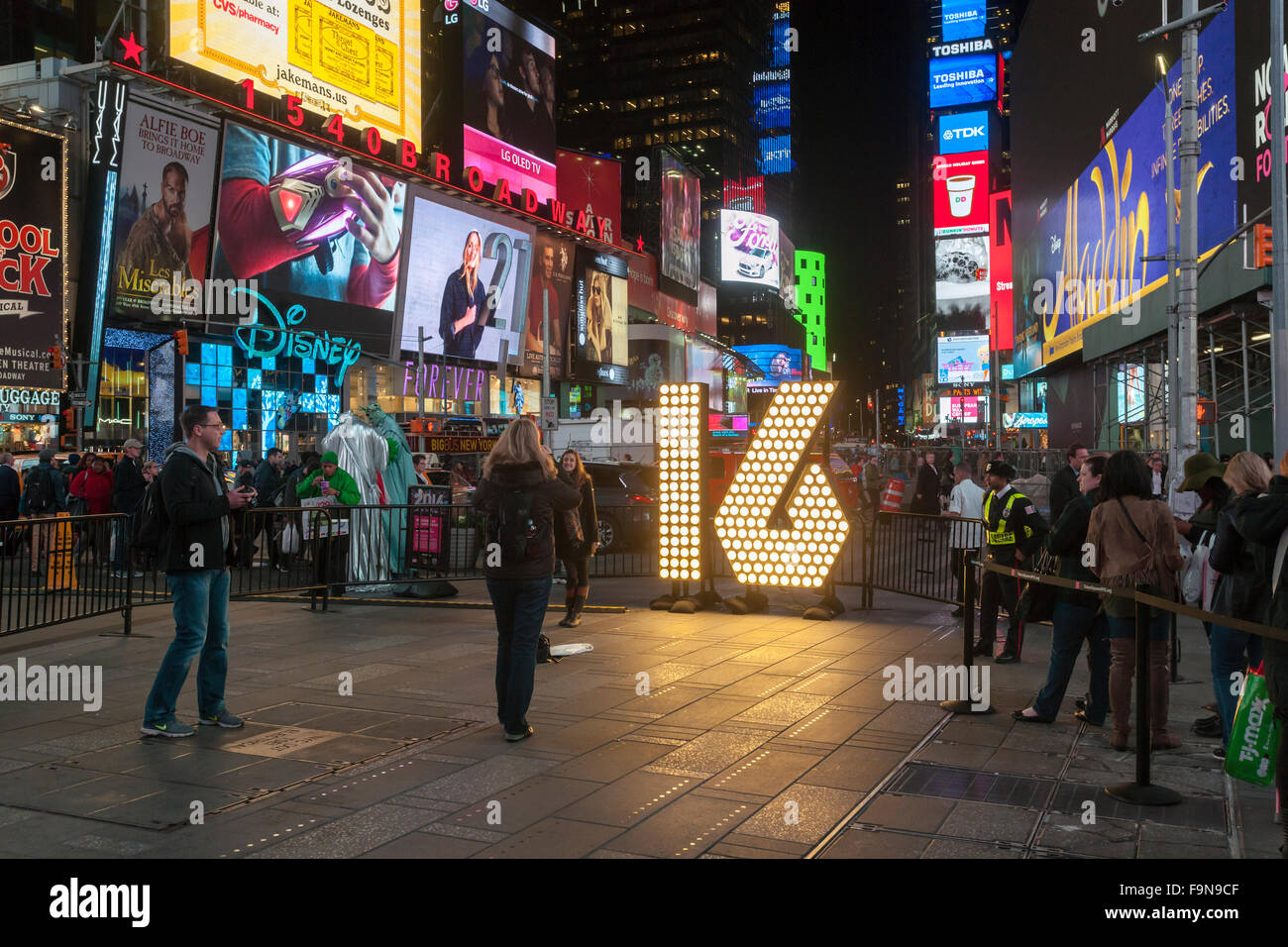 Visitors to Times Square in New York pose in front of the two seven ...