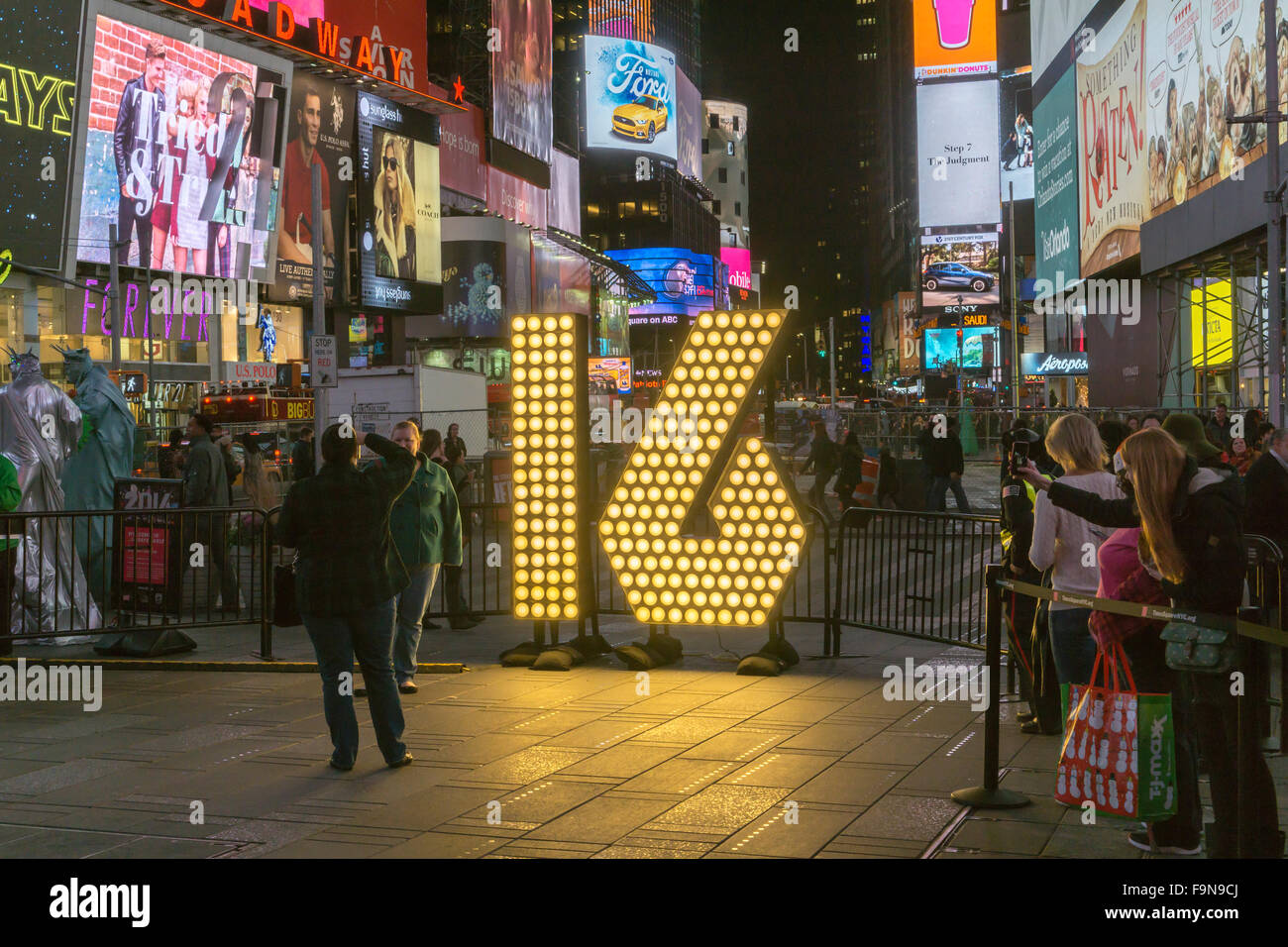 Visitors to Times Square in New York pose in front of the two seven ...