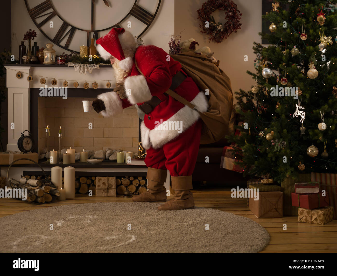 Santa Claus Drinking Milk near Fireplace at Home Stock Photo - Alamy