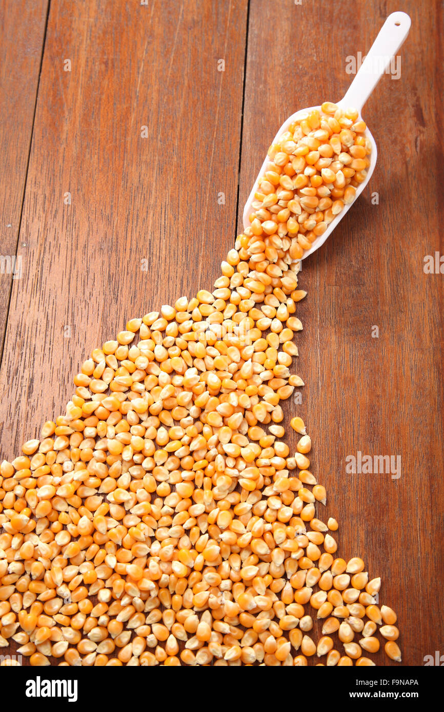 scoop of the maize corn on the wooden background Stock Photo - Alamy