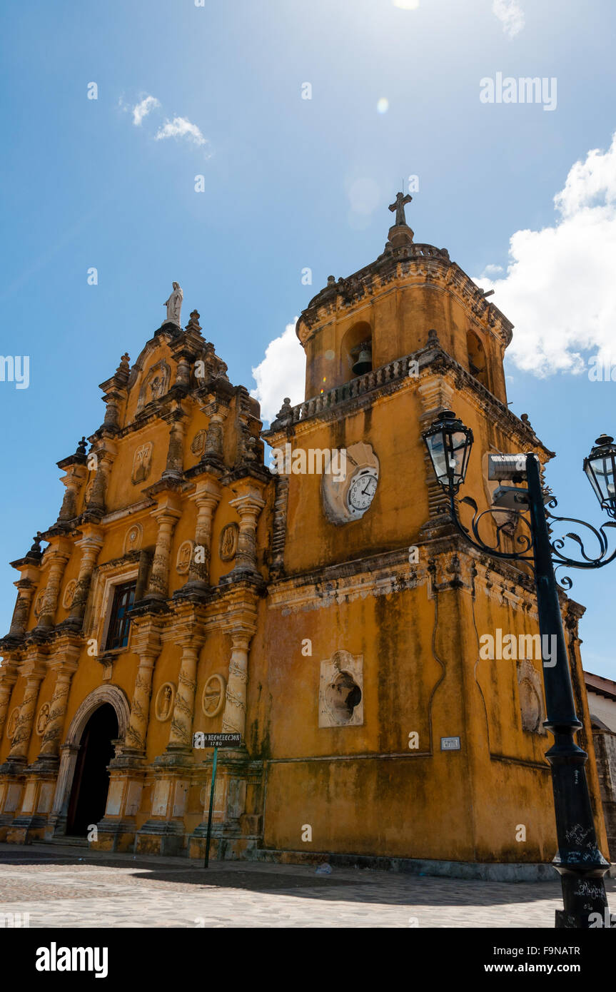 Old latern in front of yellow church with White Clock and a bell on top ...