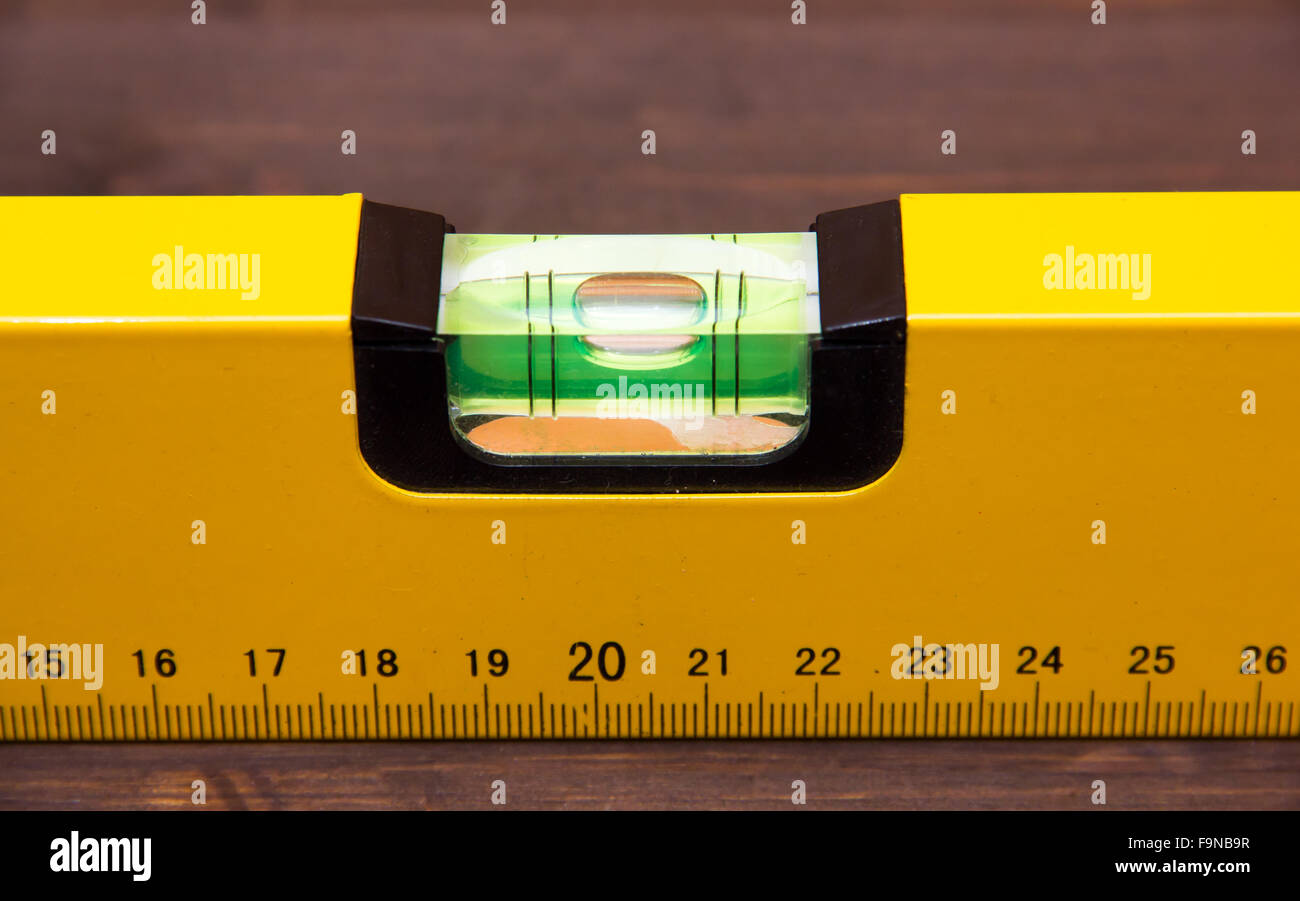 Carpenter's level on wooden table seen from very close Stock Photo - Alamy