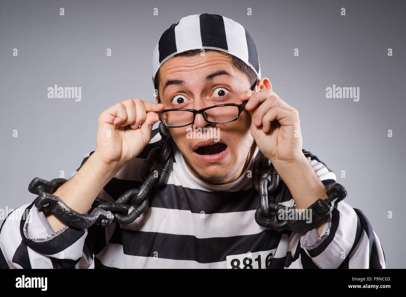 Young prisoner in chains against gray Stock Photo - Alamy