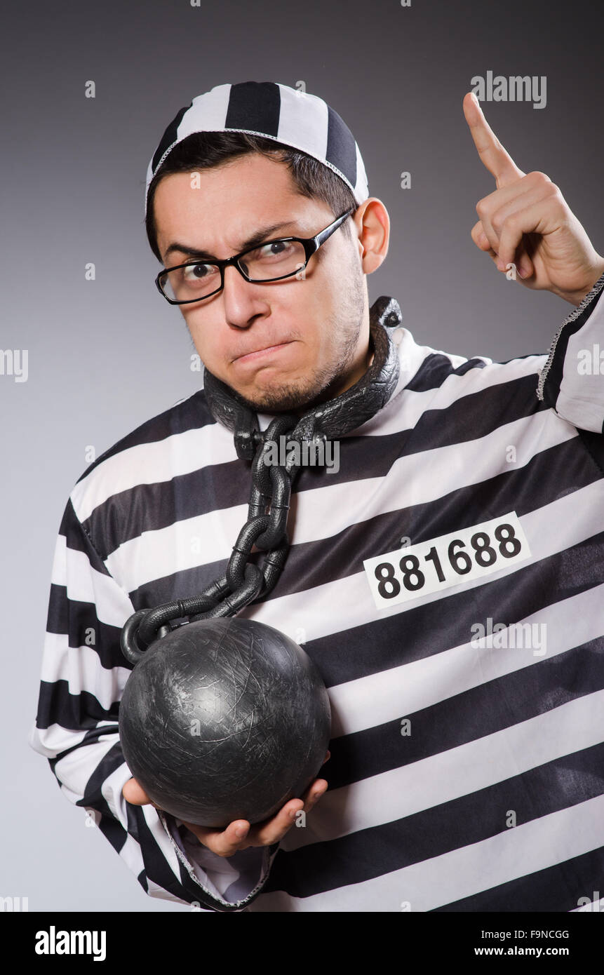 Young prisoner in chains against gray Stock Photo - Alamy