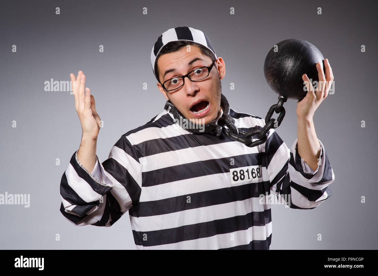 Young prisoner in chains against gray Stock Photo - Alamy