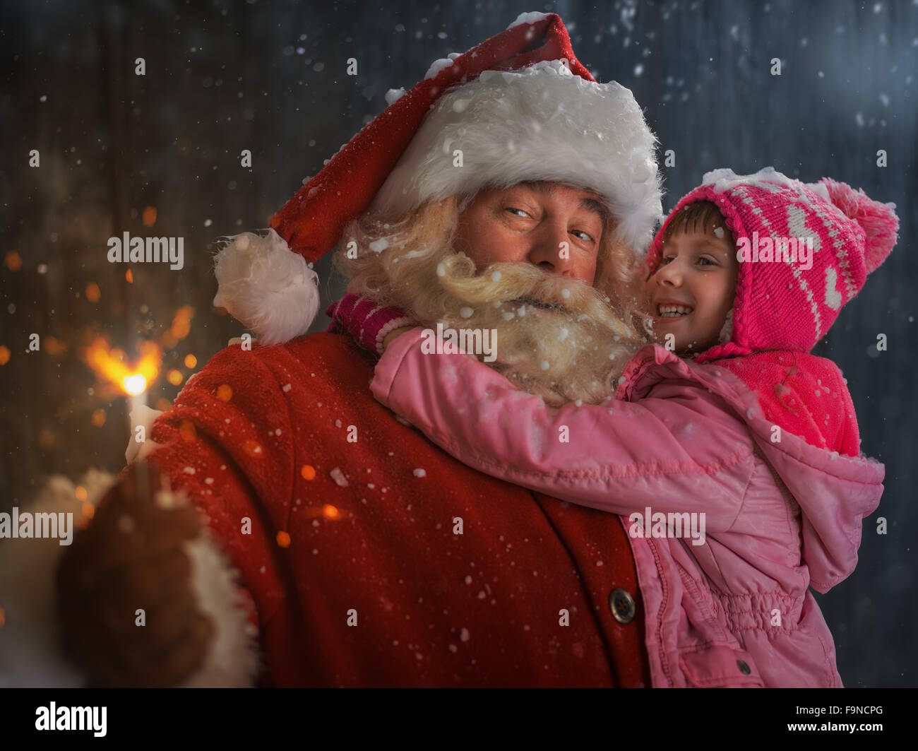 Photo of Santa Claus standing outdoors under snow with Child and ...