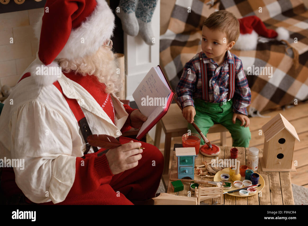Santa Claus with Child making Christmas Gifts and Toys at Home Stock ...