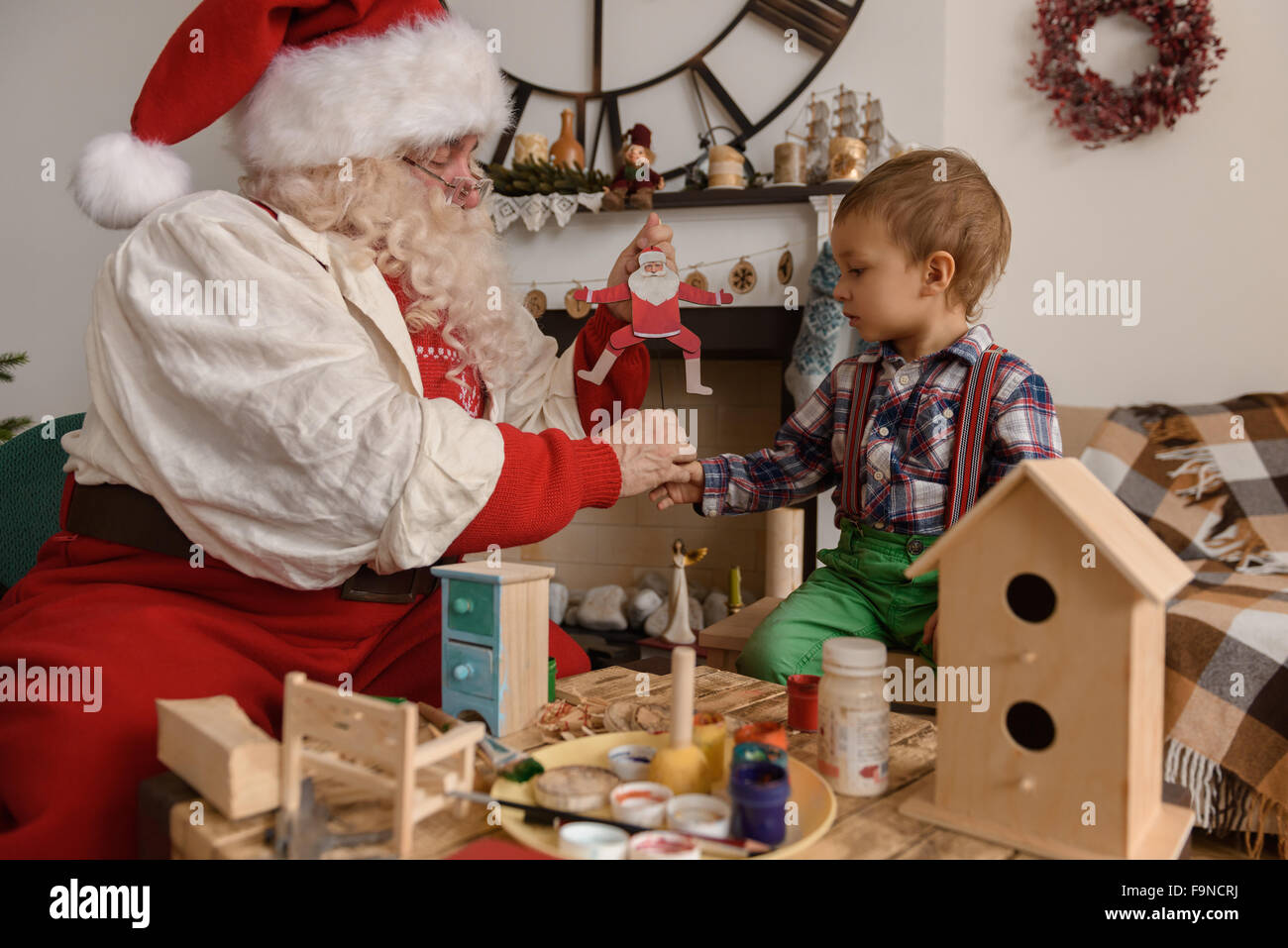 Santa Claus with Child making Christmas Gifts and Toys at Home Stock ...