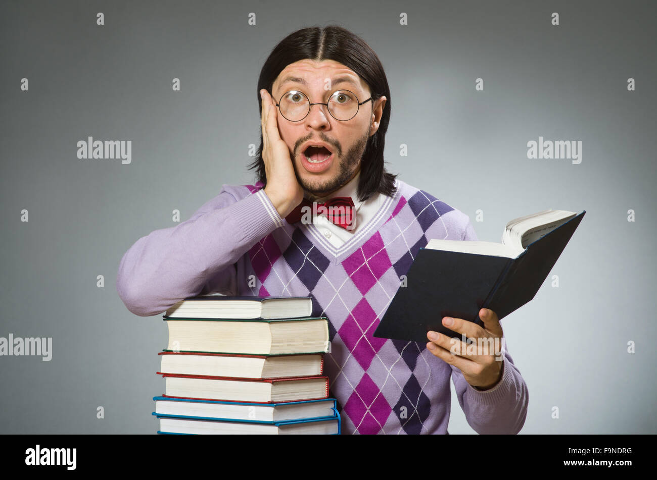 Young student with book in learning concept Stock Photo - Alamy