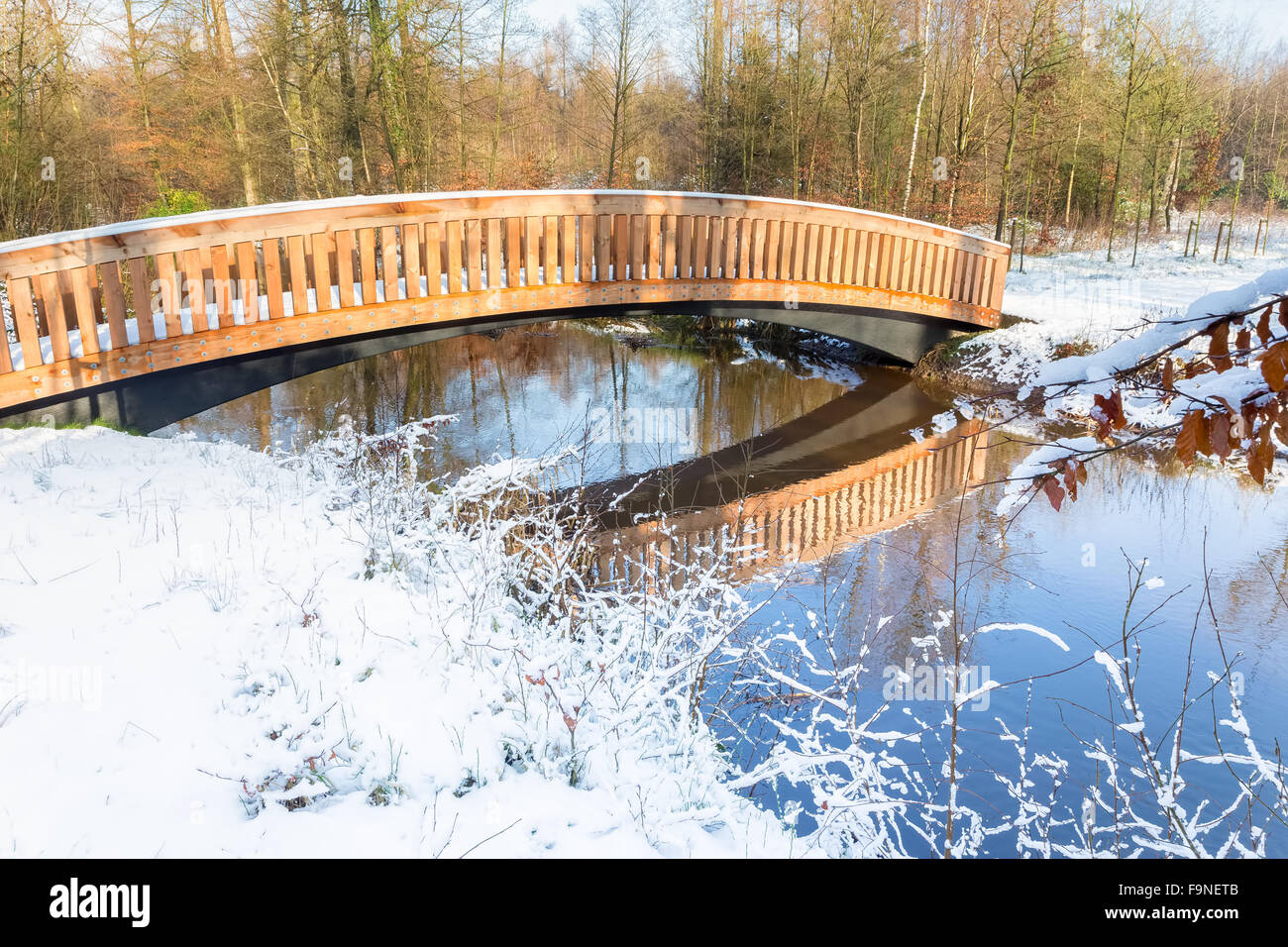Wooden pedestrian bridge with snow and water in winter landscape Stock ...