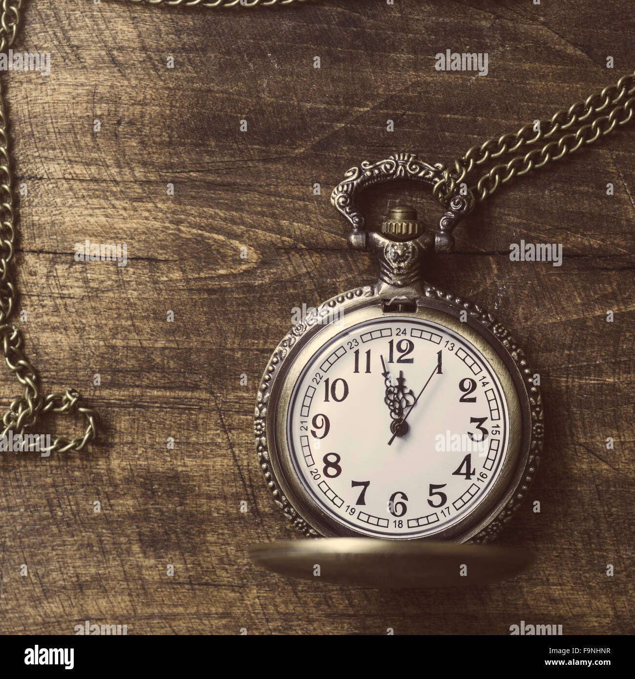 Photo of old vintage pocket watch on rustic wood. Retro filtered image ...
