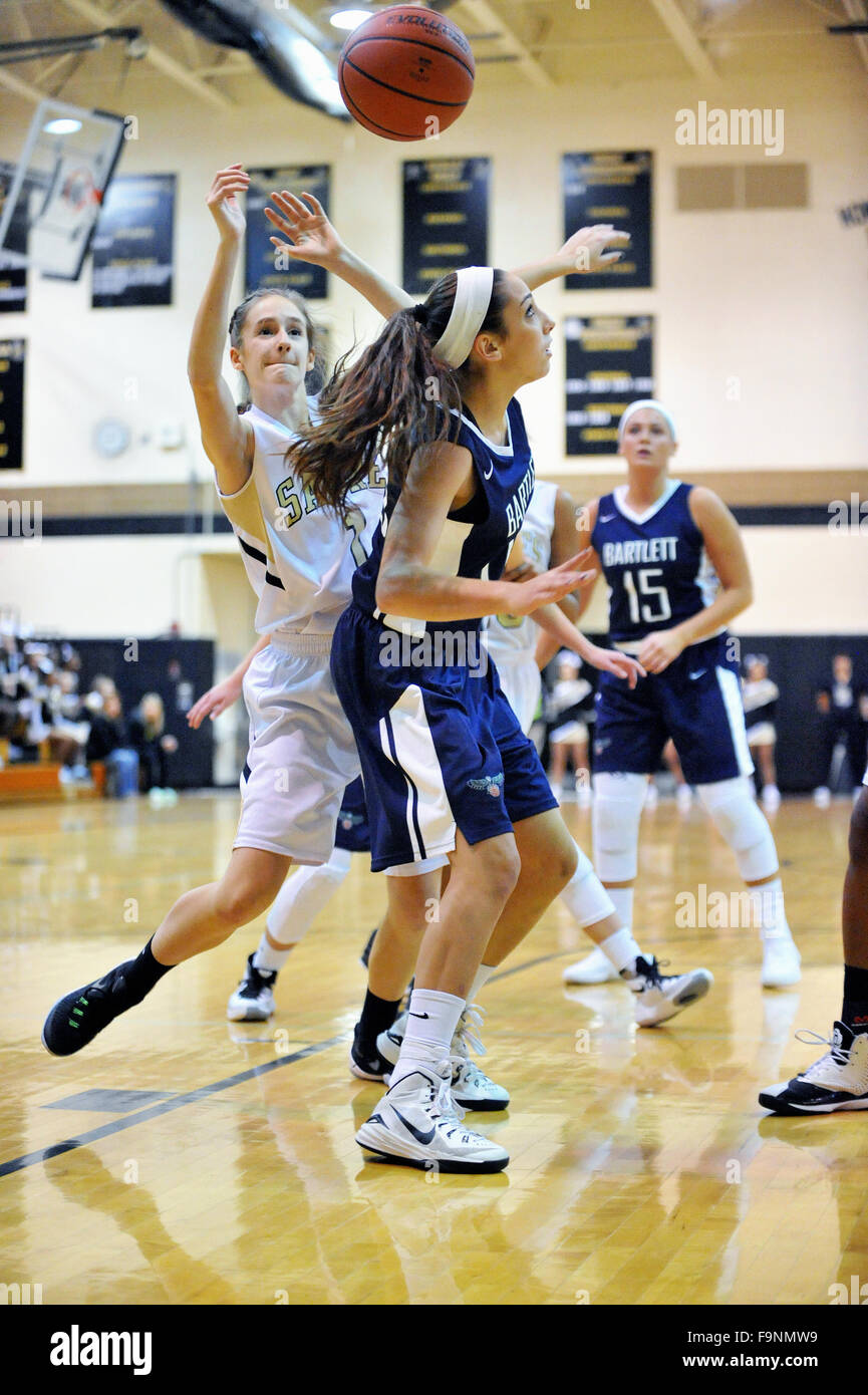 Opposing players pursue a loose ball in the lane during a high school ...