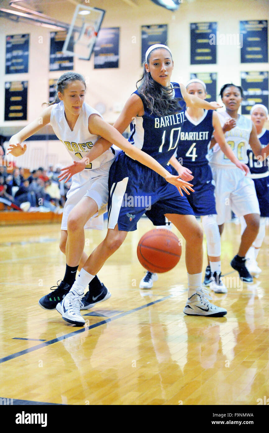 Opposing players pursue a loose ball in the lane during a high school ...