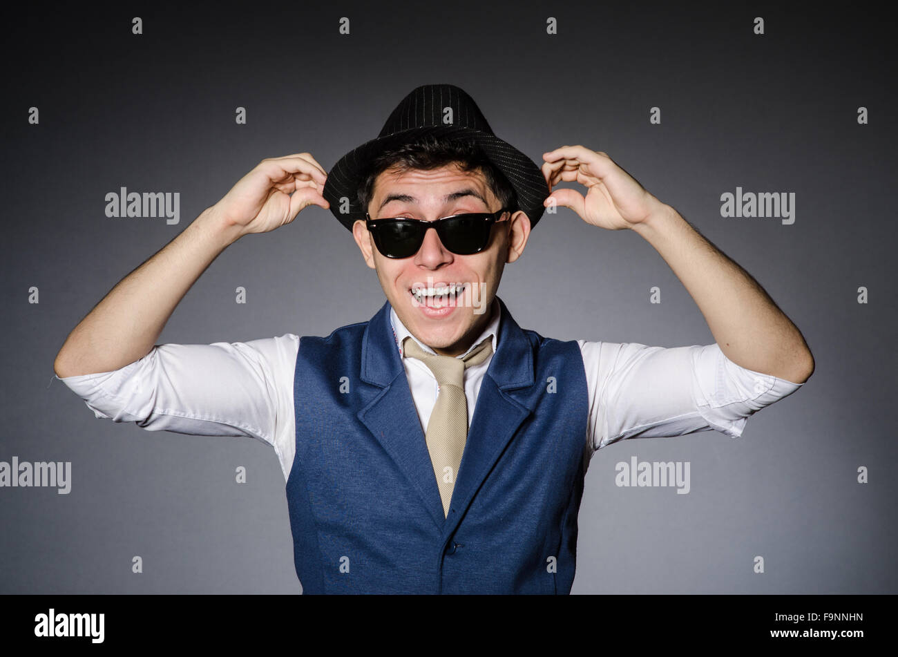 Young man in blue vest and hat against gray Stock Photo - Alamy