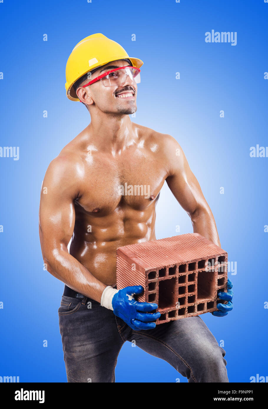 Muscular builder with bricks on white Stock Photo - Alamy
