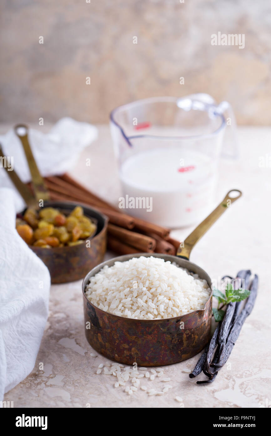 Raw rice in a measuring cup ready to cook rice pudding Stock Photo - Alamy