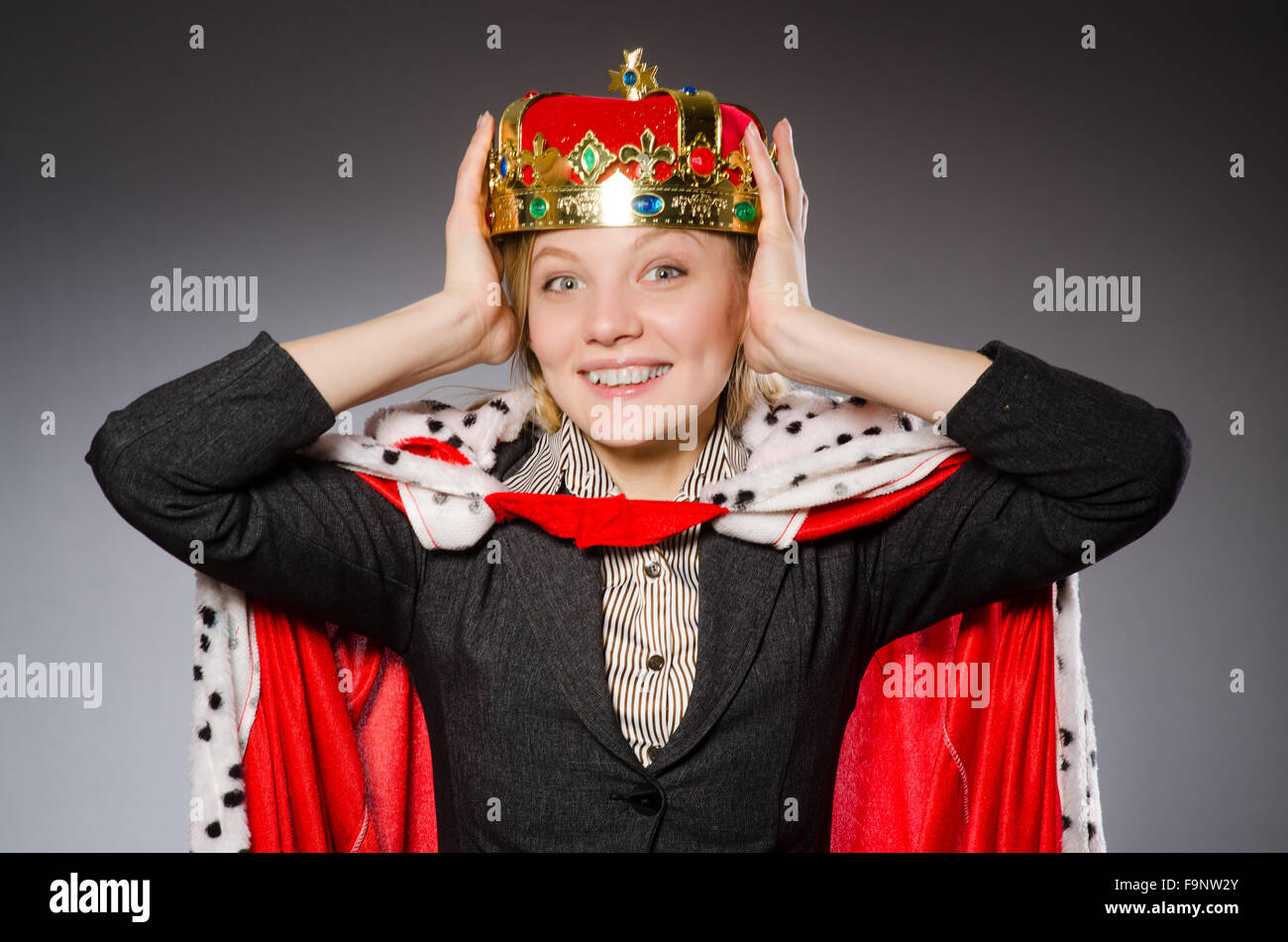 Businesslady wearing crown against gray Stock Photo - Alamy