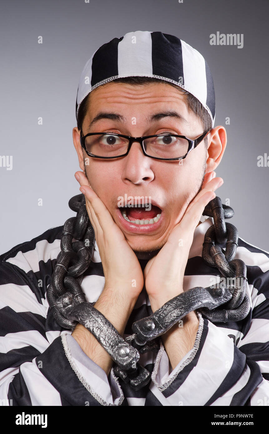 Young prisoner in chains against gray Stock Photo - Alamy