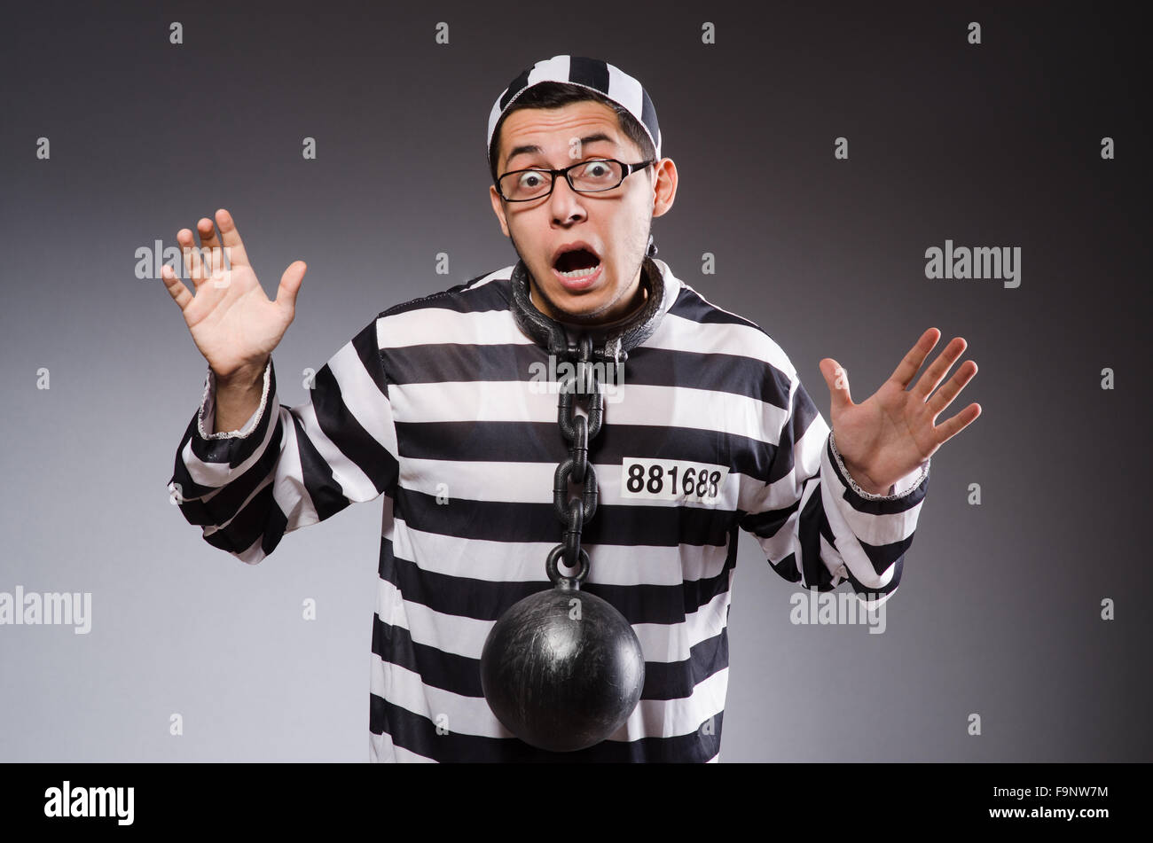 Young prisoner in chains against gray Stock Photo - Alamy