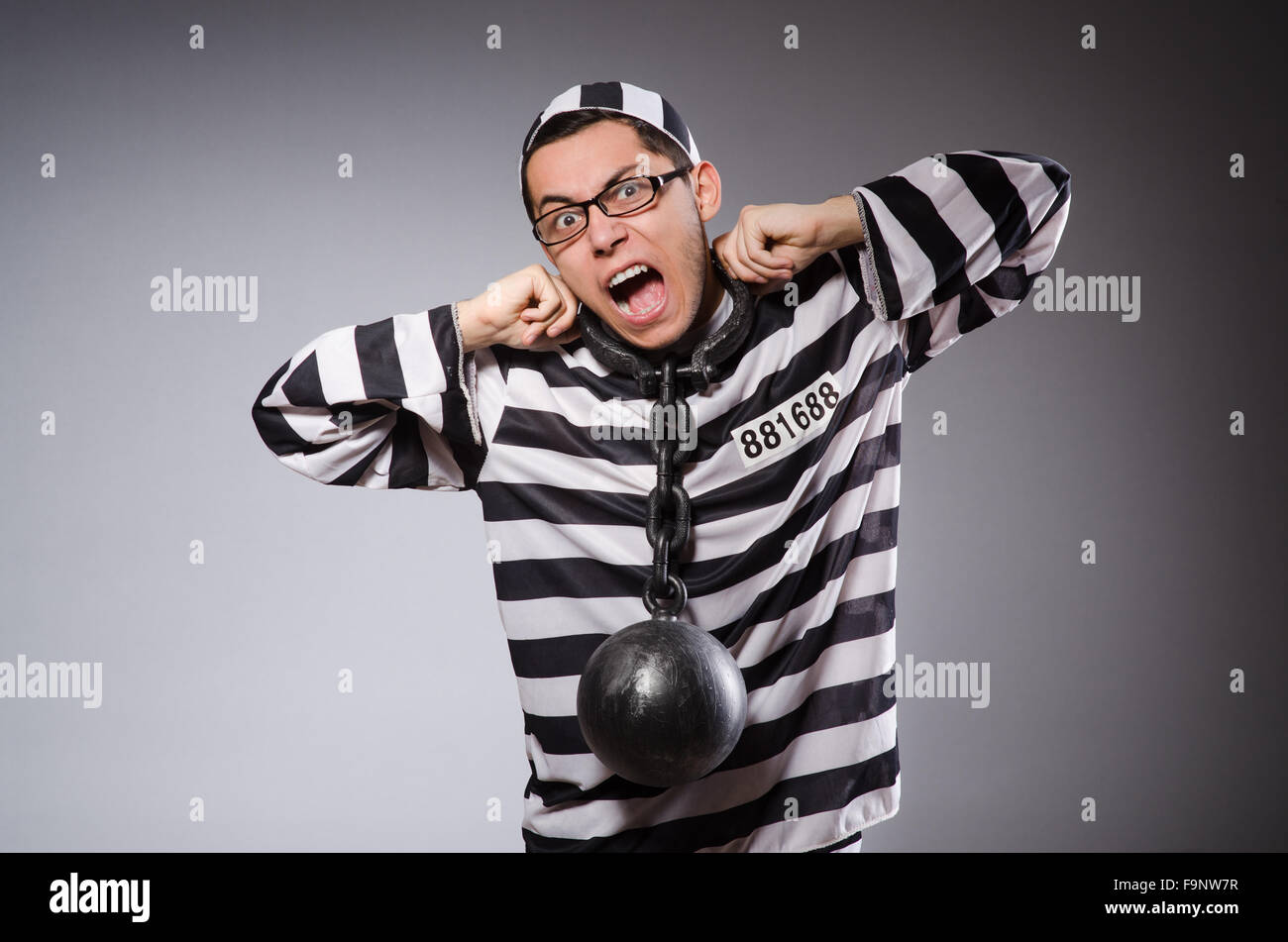 Young prisoner in chains against gray Stock Photo - Alamy