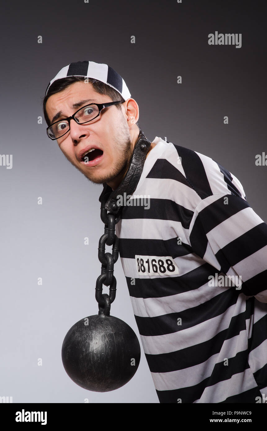Young prisoner in chains against gray Stock Photo - Alamy