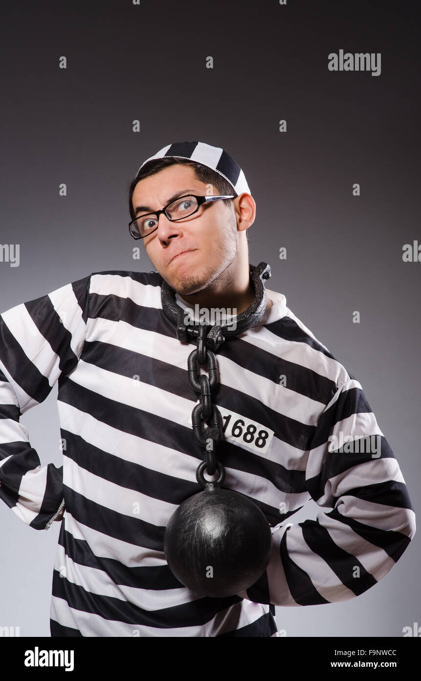 Young prisoner in chains against gray Stock Photo - Alamy