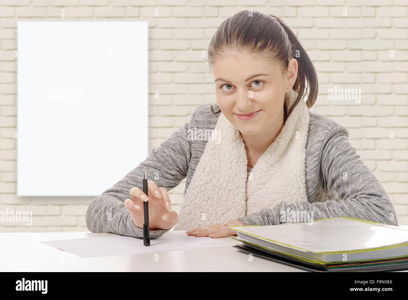 a pretty young woman writing on her desk Stock Photo - Alamy