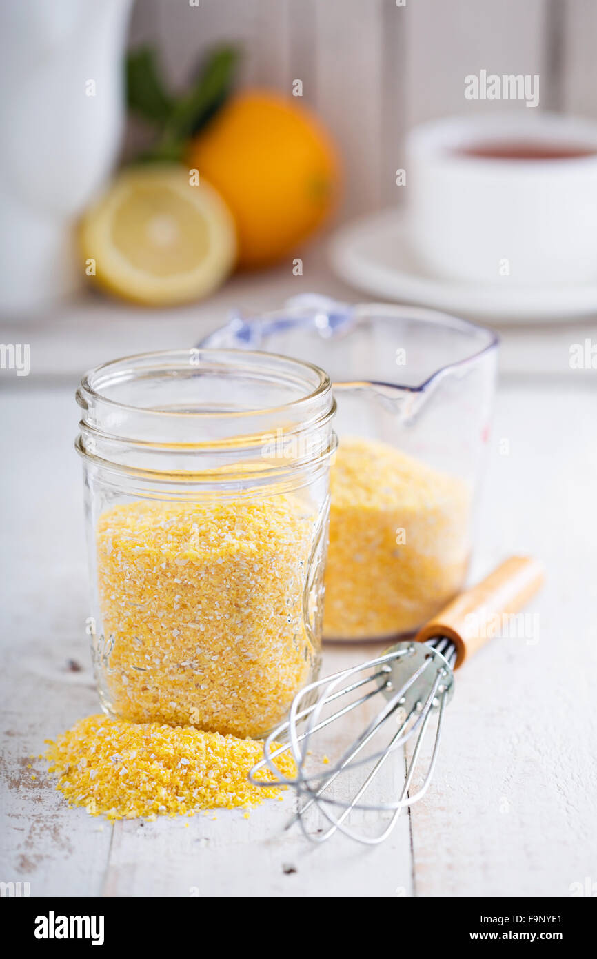 Raw cornmeal in a jar and measuring cup with a whisk Stock Photo - Alamy