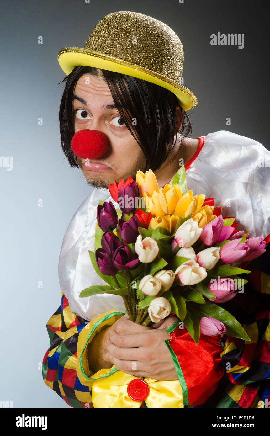 Clown with tulip flowers in funny concept Stock Photo - Alamy