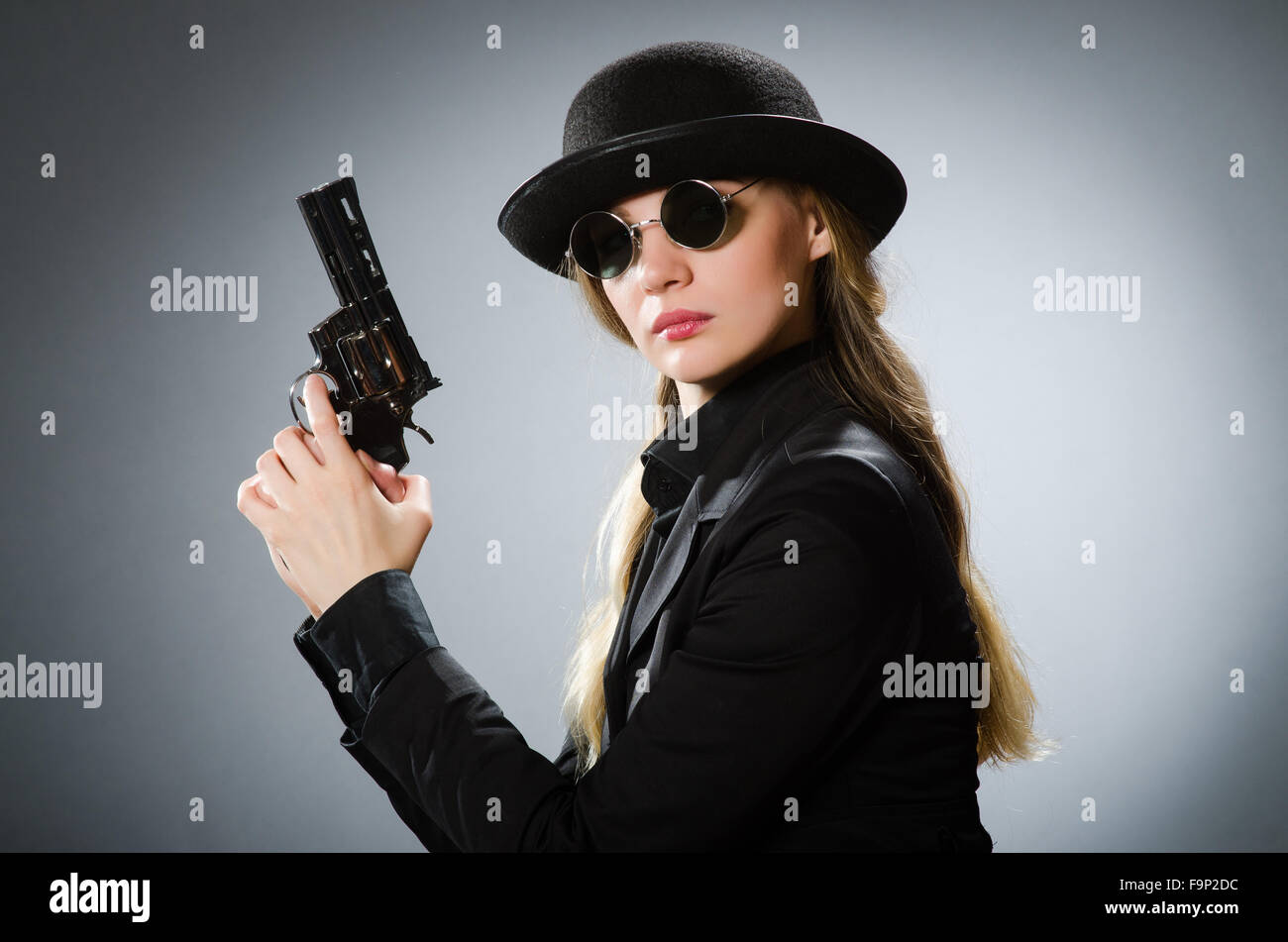 Female spy with weapon against gray Stock Photo - Alamy Female spy with weapon against gray Stock Photo - Alamy