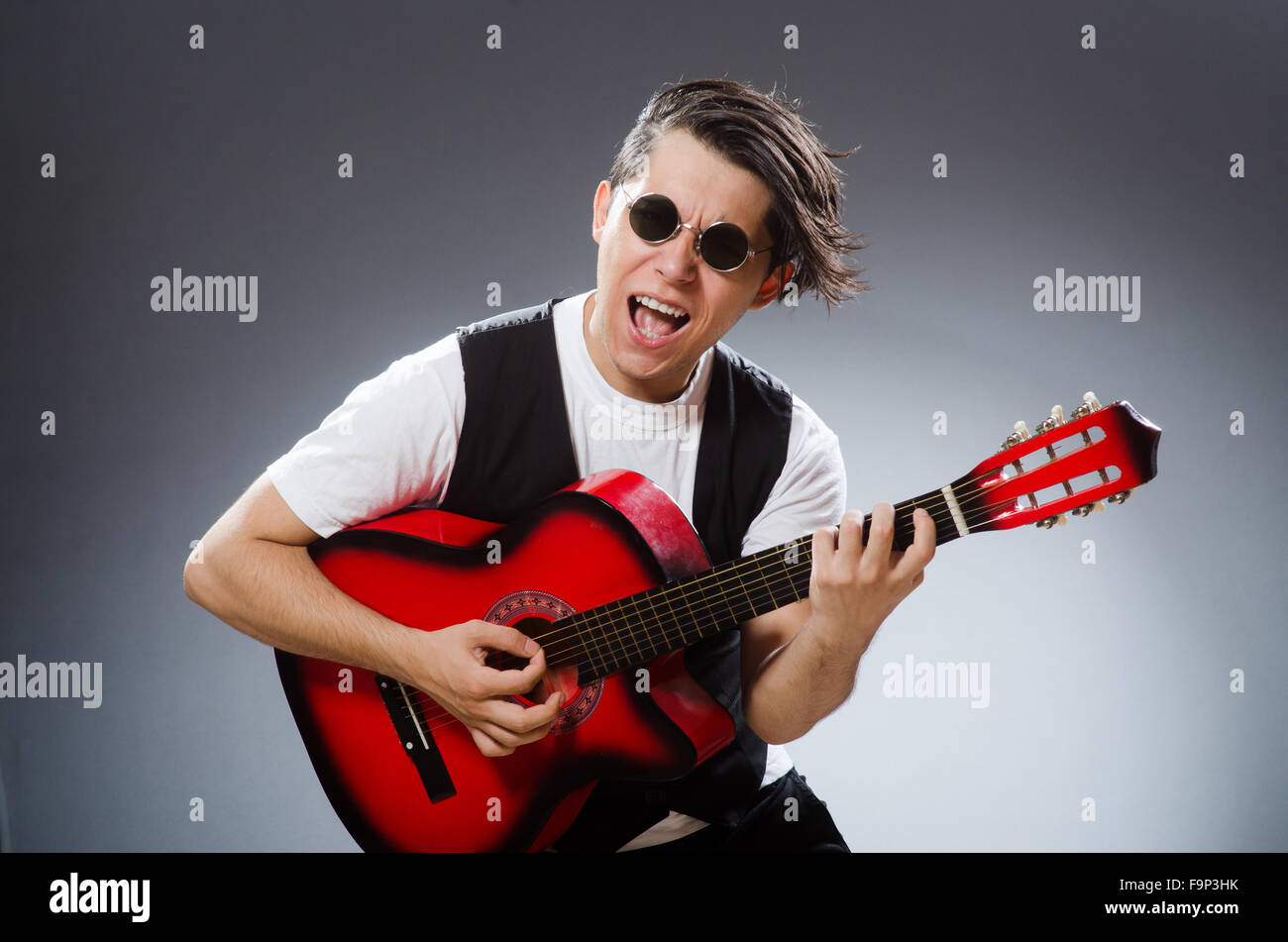Funny guitar player in musical concept Stock Photo - Alamy