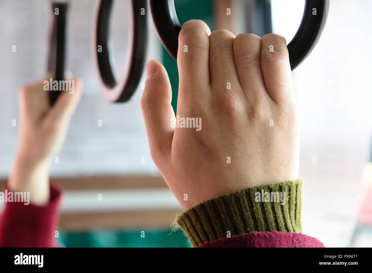 people holding onto a handle on a bus Stock Photo - Alamy