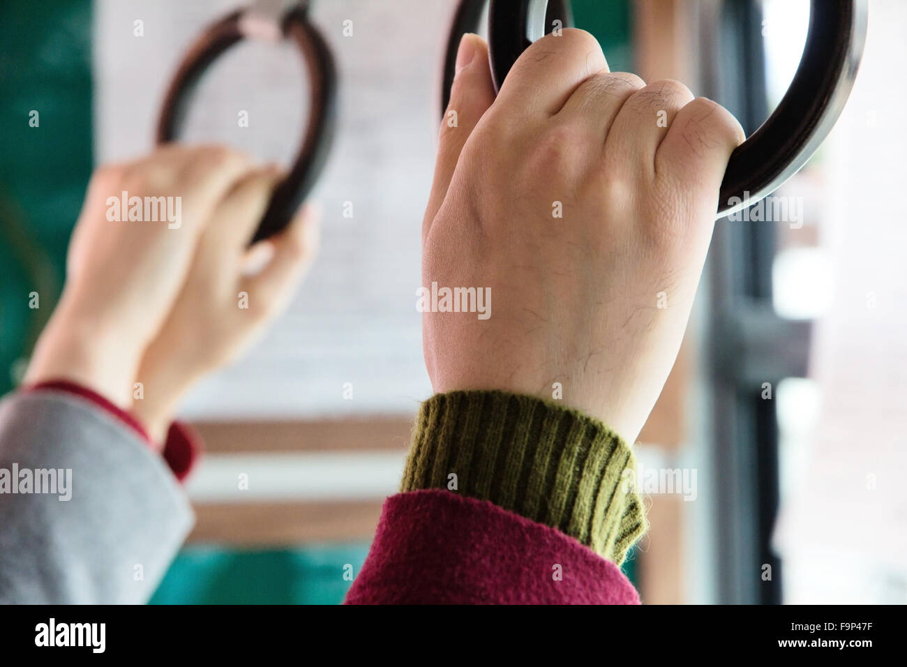 people holding onto a handle on a bus Stock Photo - Alamy