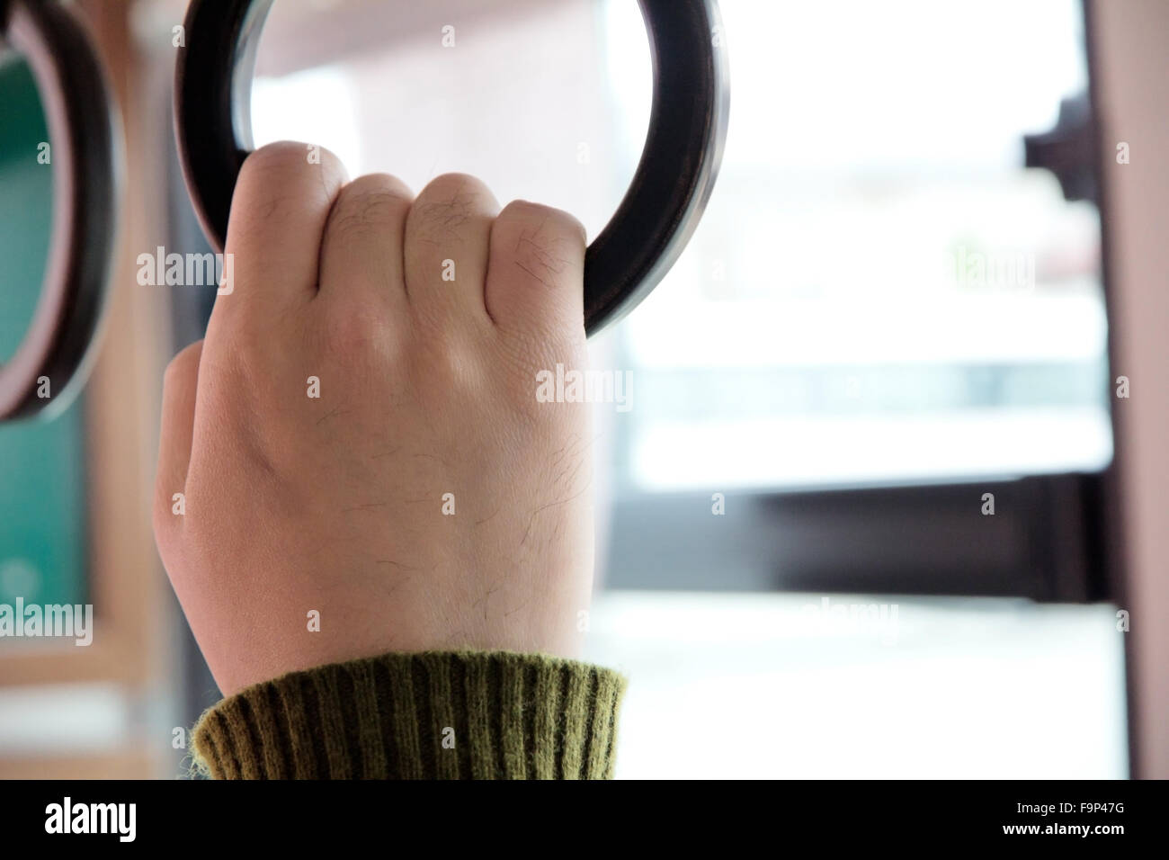 people holding onto a handle on a bus Stock Photo - Alamy