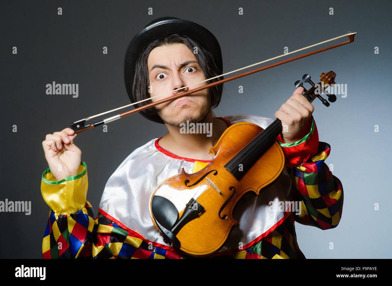 Funny violin clown player in musical concept Stock Photo - Alamy