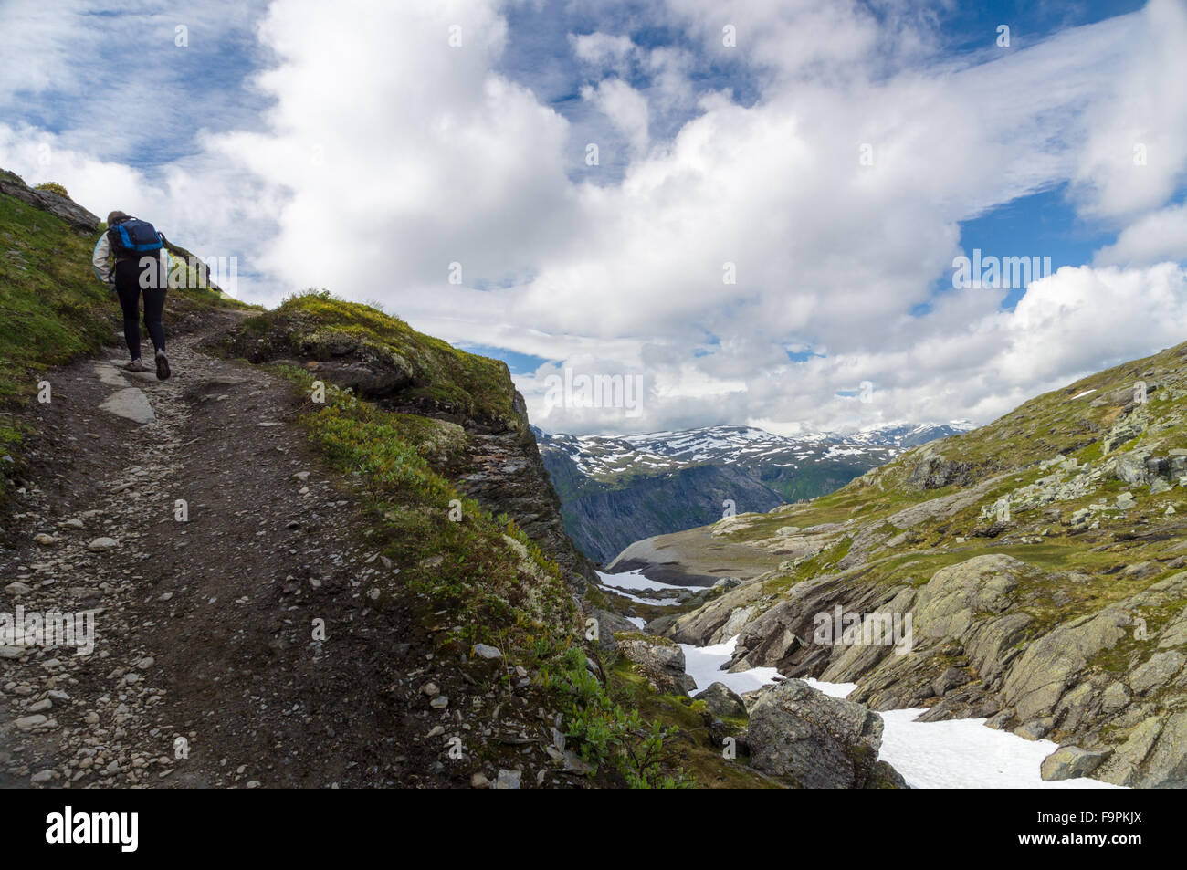 Young woman with backpack climbing in highland trail, scenic mountains ...