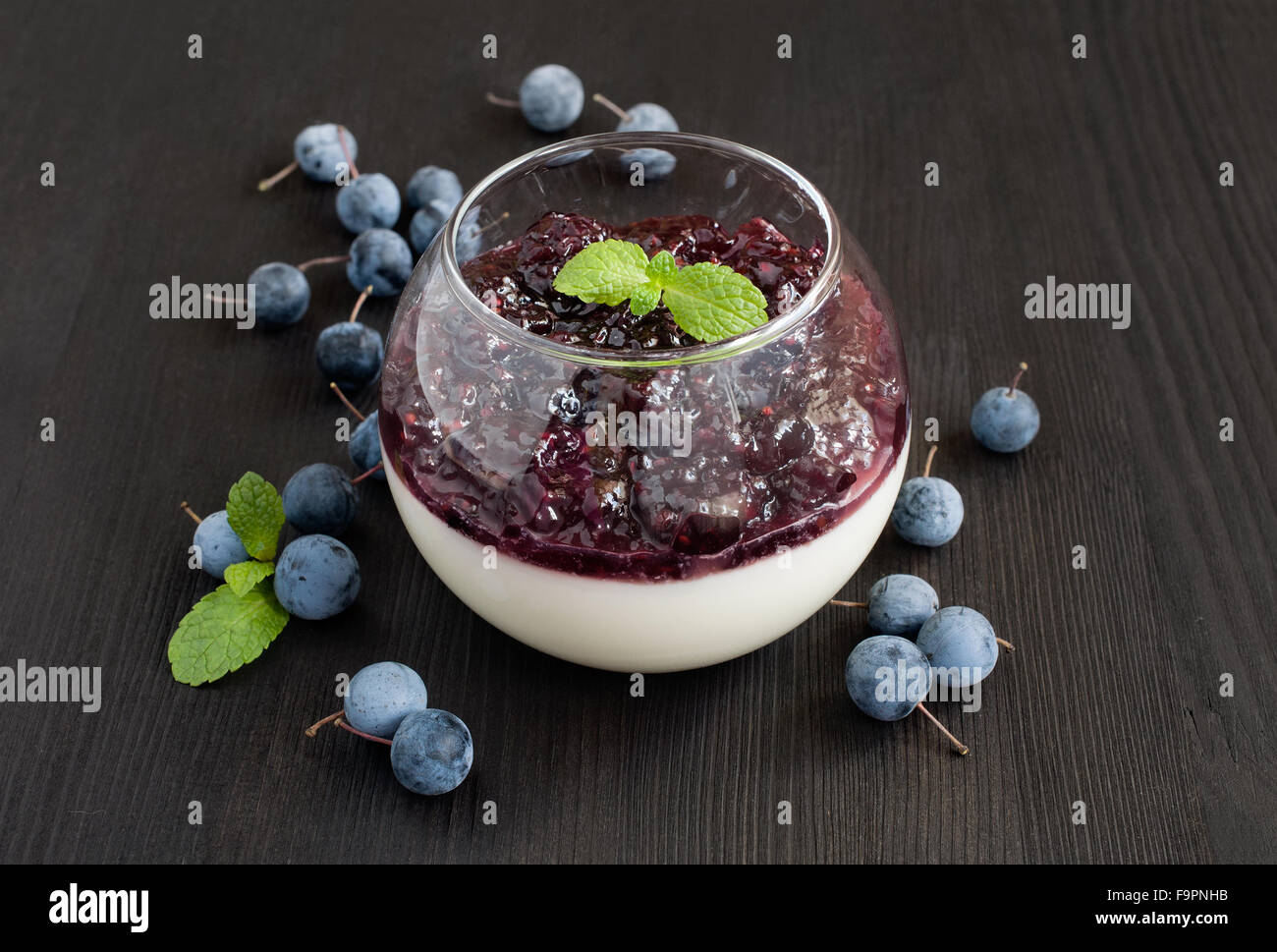 Panna Cotta with fresh blackthorn on black background Stock Photo - Alamy
