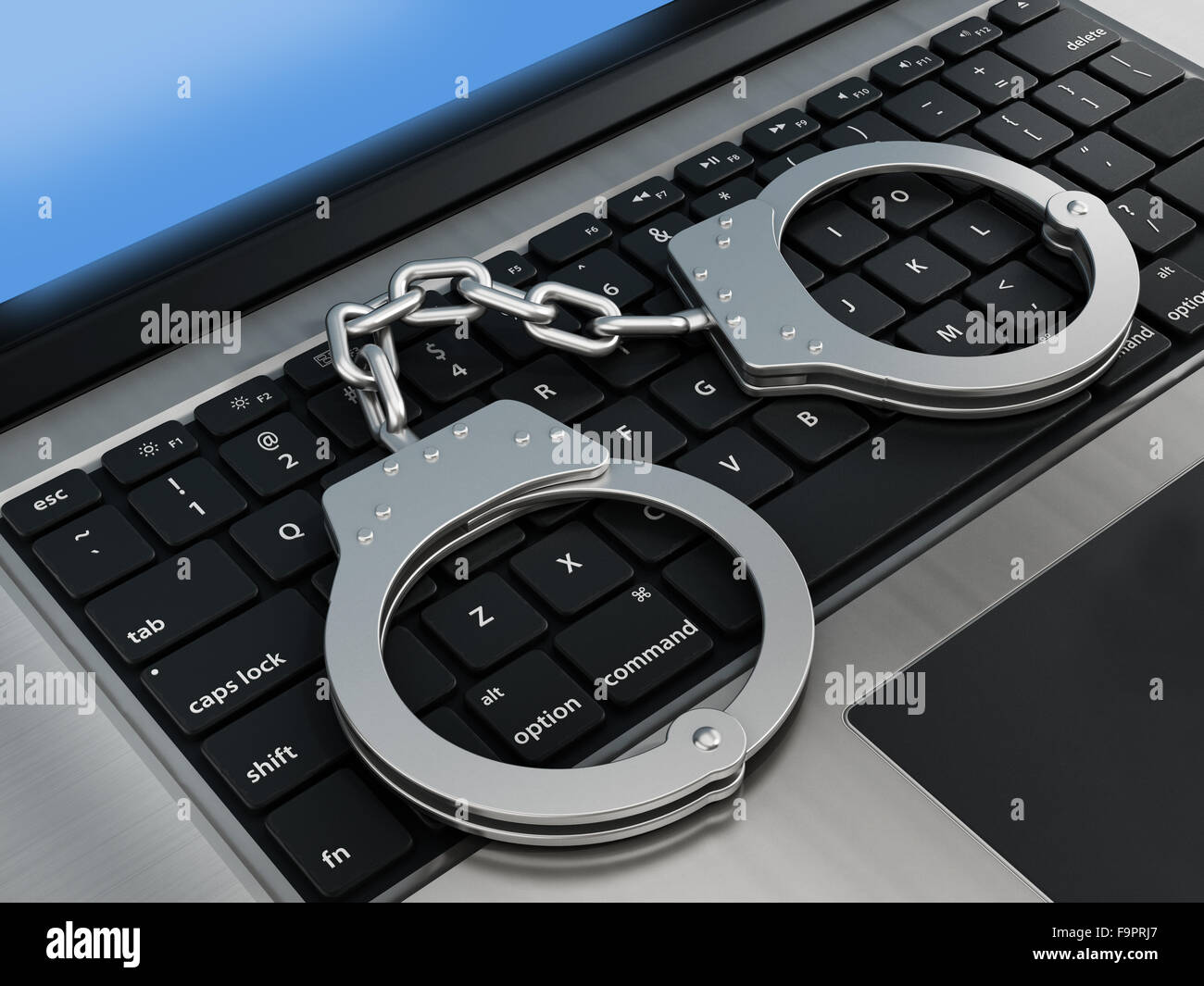 Handcuffs standing on laptop computer keyboard Stock Photo - Alamy