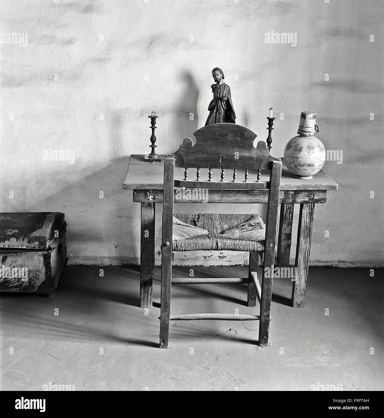 A black and white photograph of a monk's desk in a California mission ...