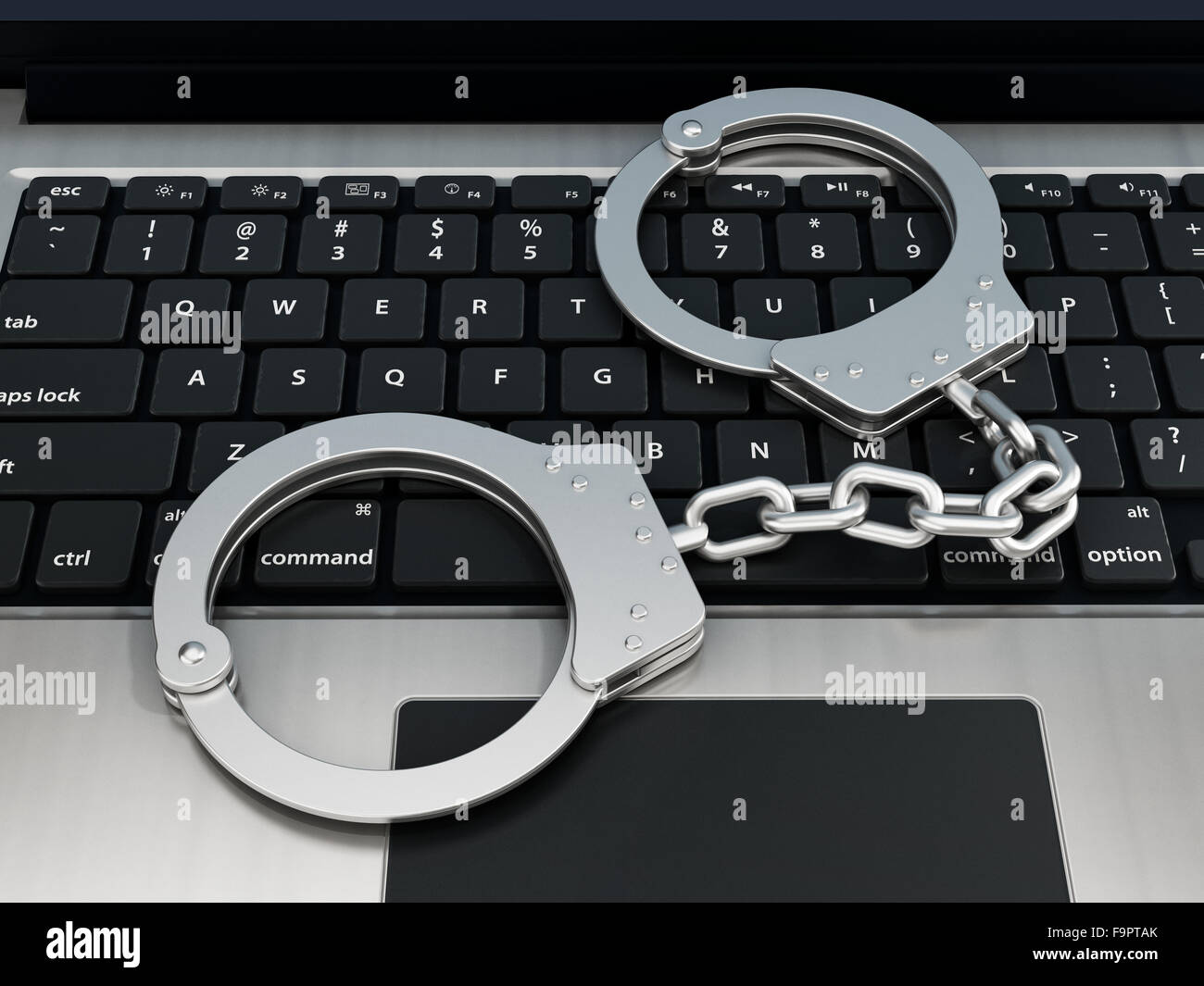 Handcuffs standing on laptop computer keyboard Stock Photo - Alamy
